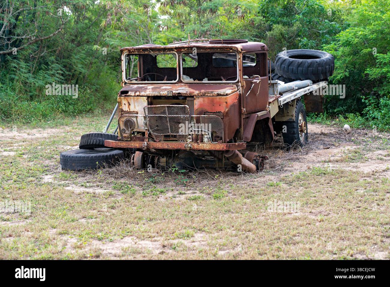 Old decaying vehicle with corroded metal and exposed structure, left to ...