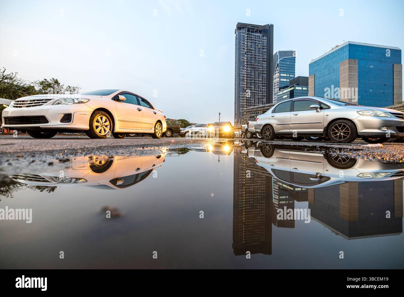 A car driving past a flooded area after heavy rainfall in an urban ...