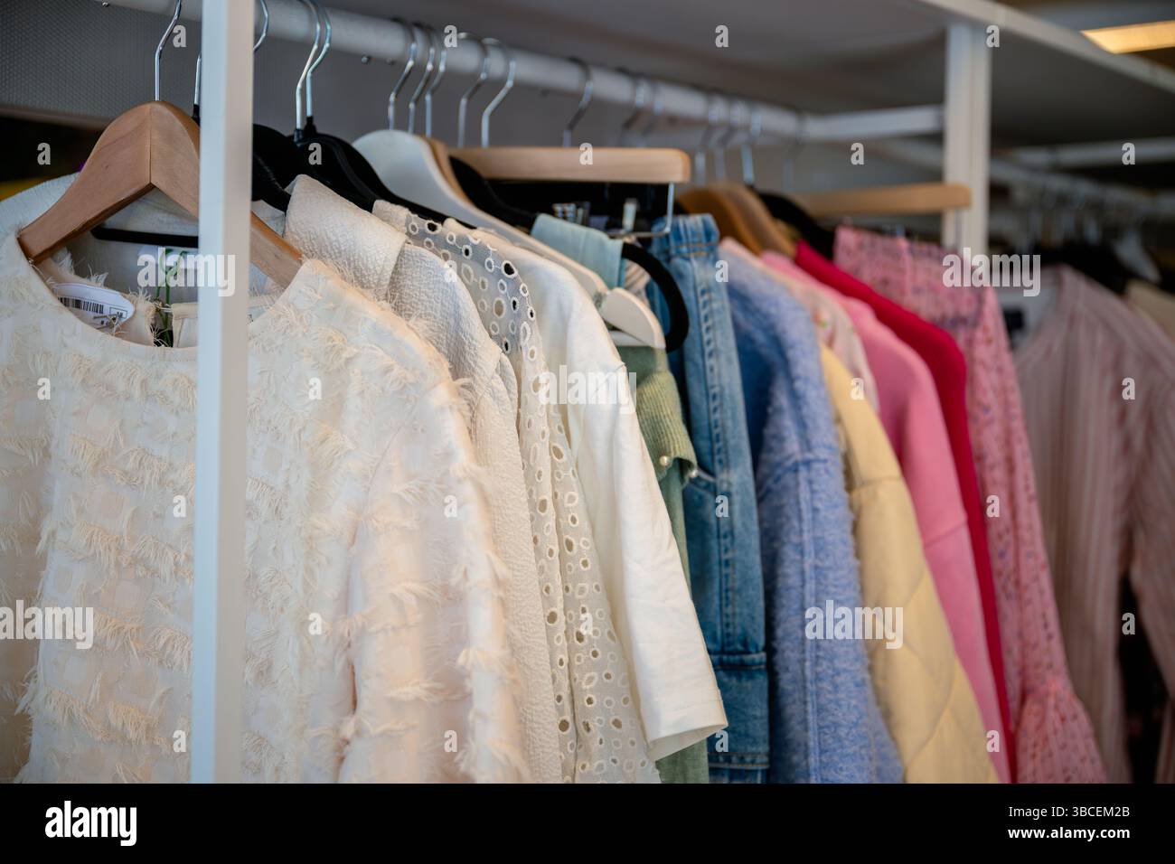 women's summer clothing in various colors and fabrics hanging on ...