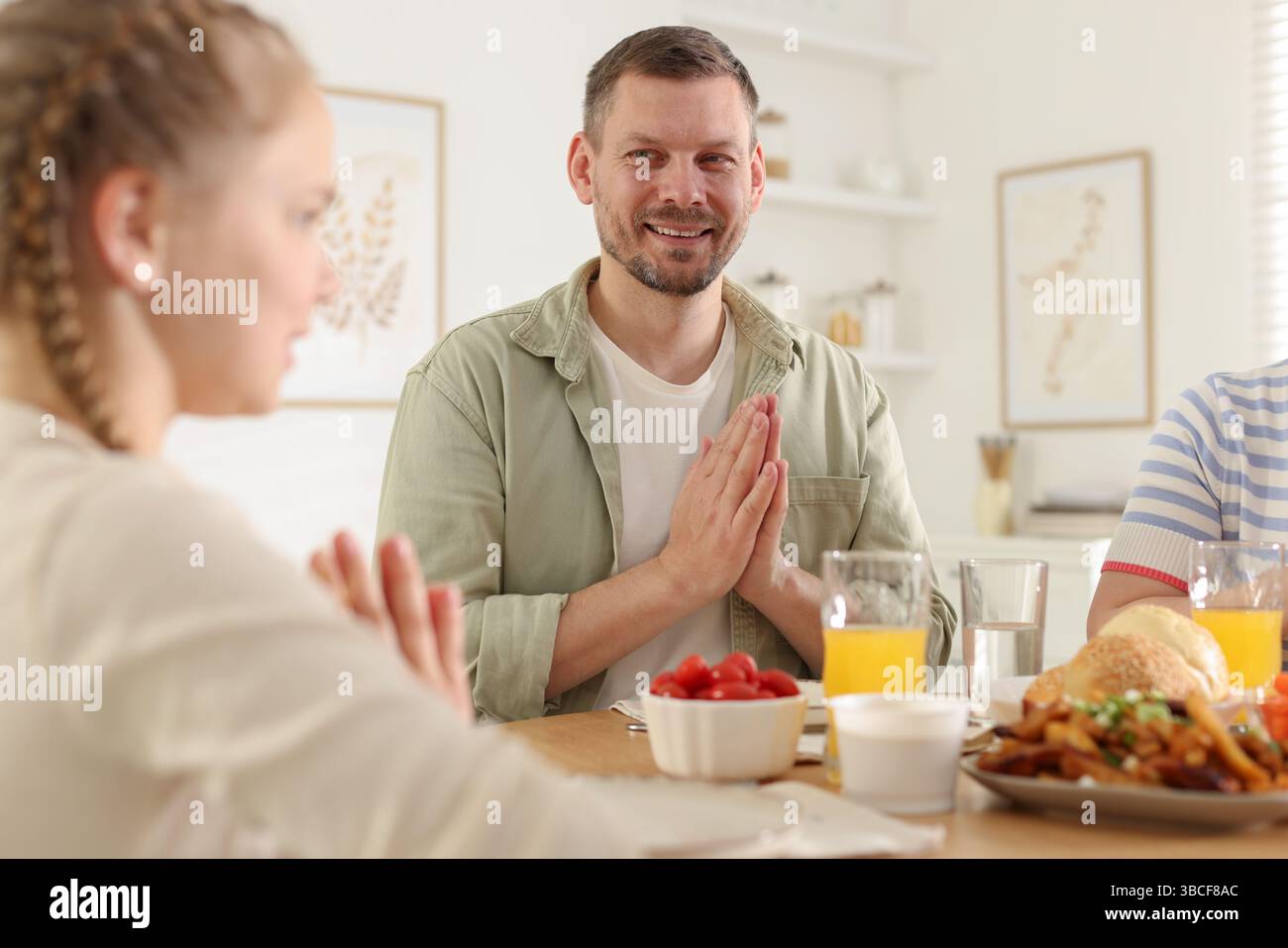 Family praying together before dinner at table indoors Stock Photo - Alamy