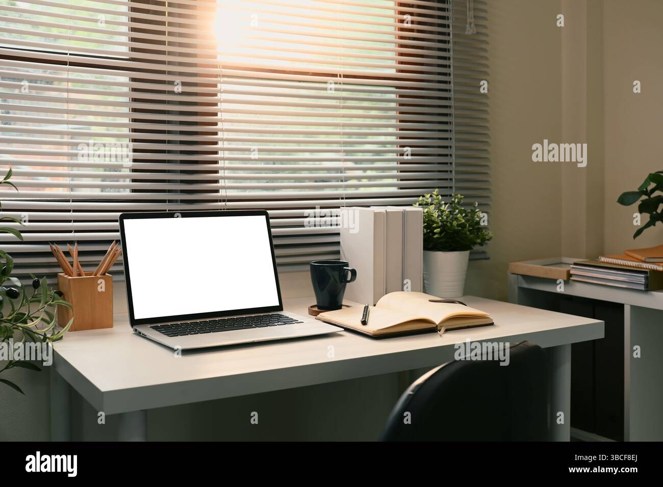 Laptop with blank screen by the window with soft sunlight streaming ...