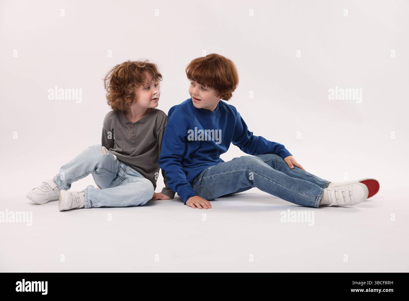 Cute little brothers posing on white background Stock Photo - Alamy