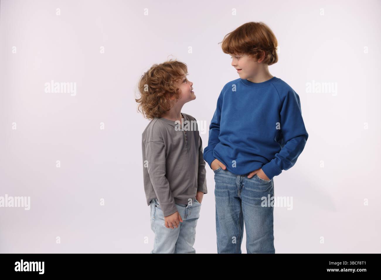 Cute little brothers posing on white background Stock Photo - Alamy