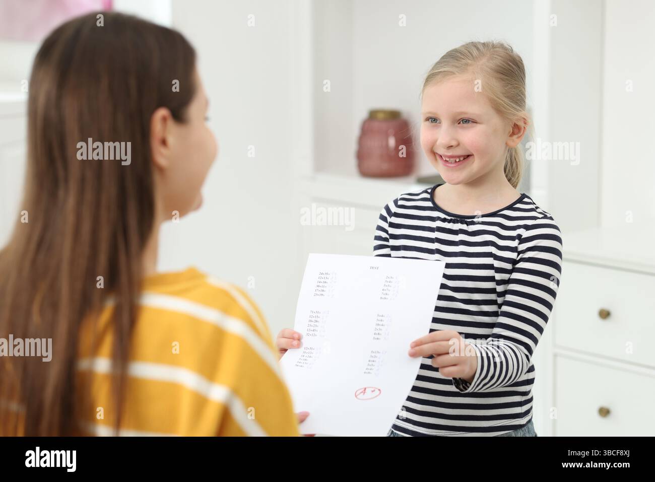 School grade. Happy girl showing answer sheet with excellent mark to ...