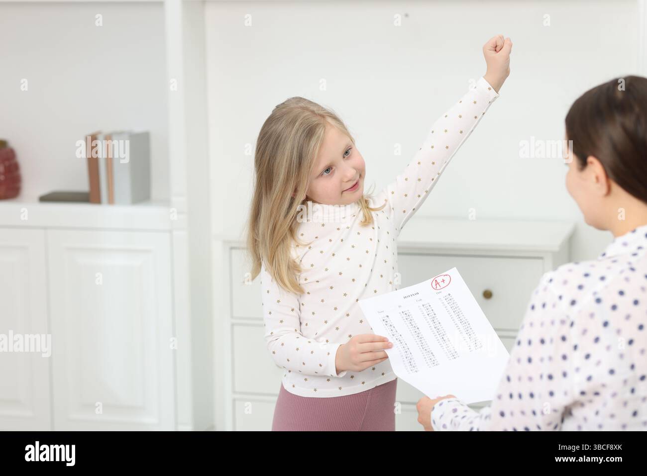 School grade. Happy girl showing answer sheet with excellent mark to ...