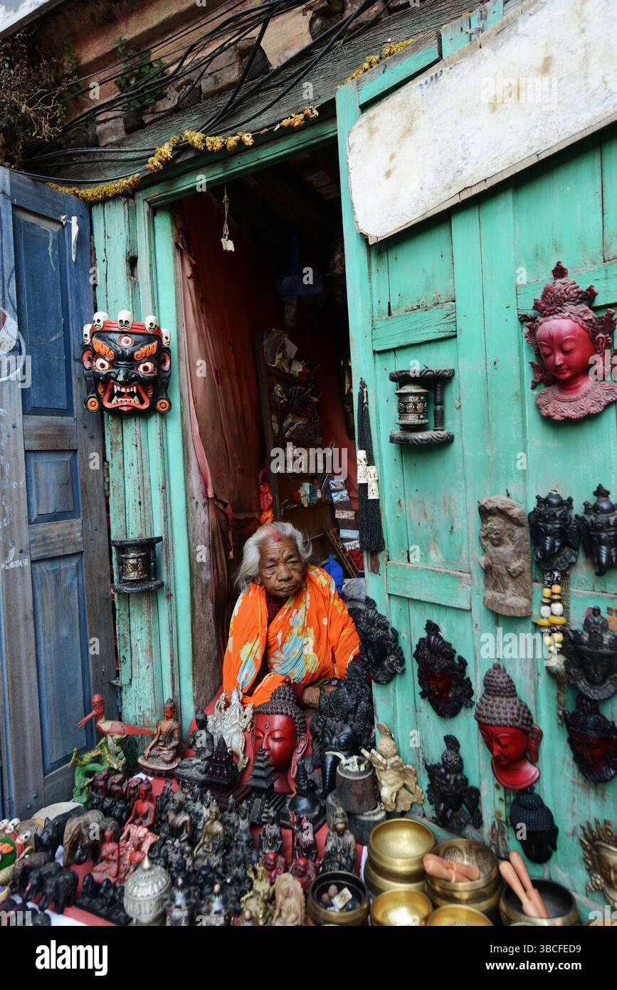 An elderly Nepali woman selling artifacts at a shop at the Durbar Square in Patan, Nepal Stock ...