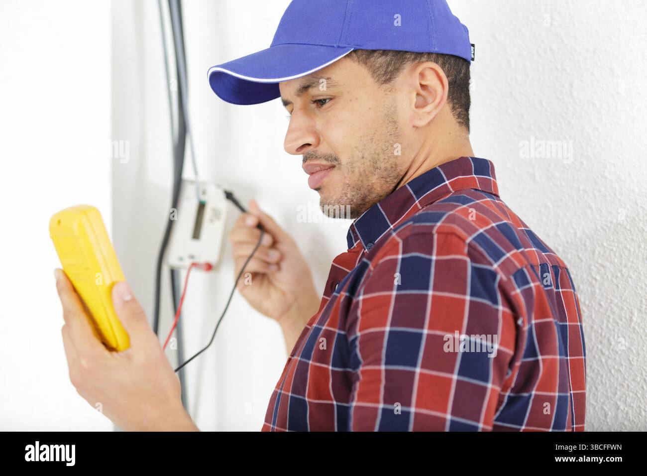 male electrician using multimeter to test wiring Stock Photo - Alamy