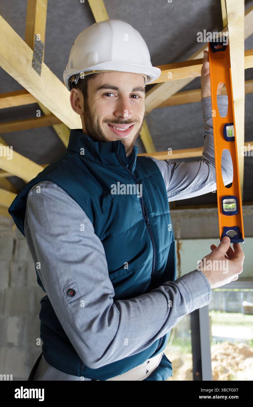 happy construction worker checking vertical level of column Stock Photo - Alamy