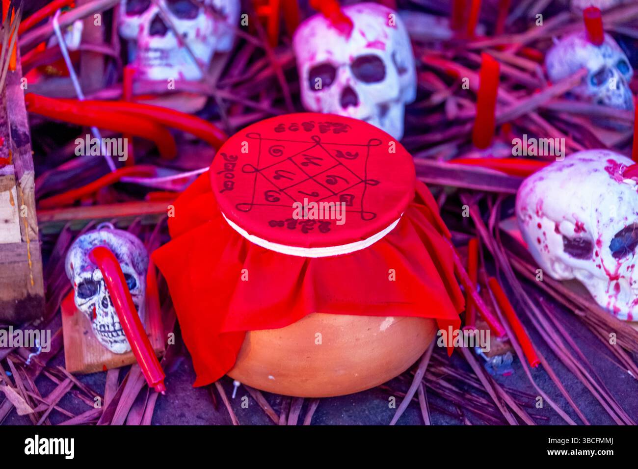 Fake Thai ghost pot surrounded by fake human skulls with red candles to ...