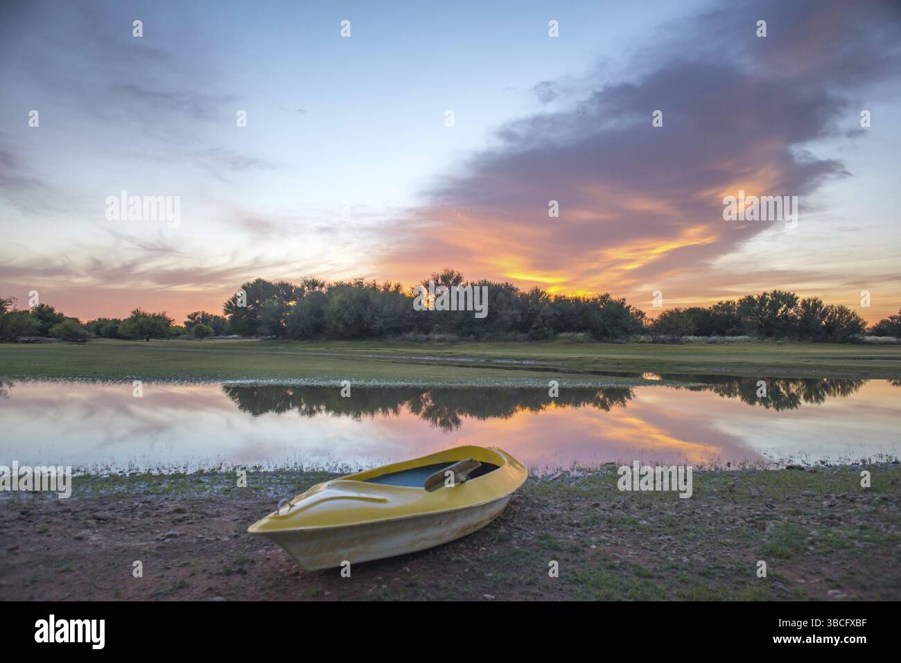An early morning sunrise over a natural watery landscape, with a yellow ...