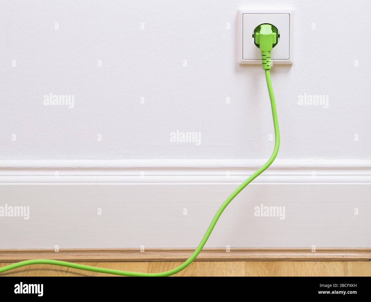 The photo shows a green power cable in a socket outlet Stock Photo - Alamy