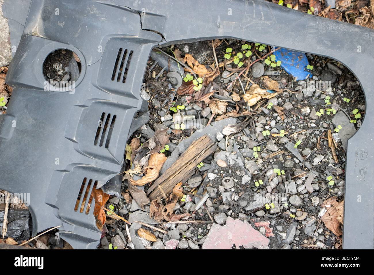 pile of dirt and old tarmac with litter and car parts on the road side ...