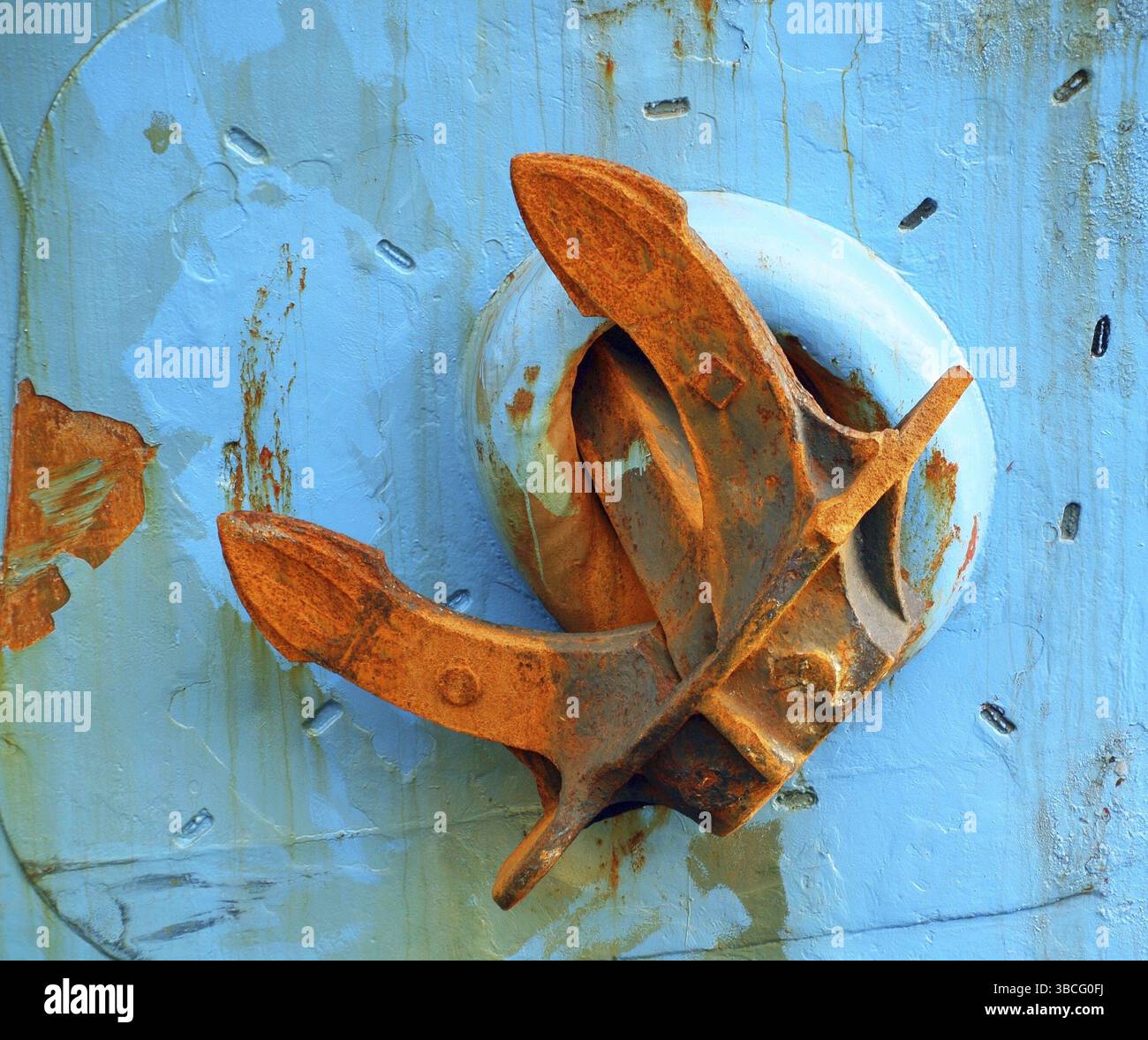 A massive anchor with rust is fastened on the side of a blue ship Stock ...