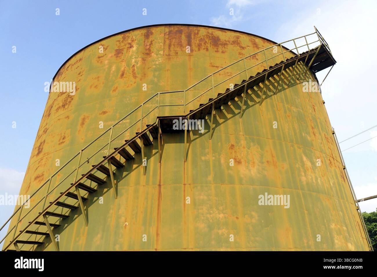 A large rusting storage tank at a vintage industrial facility Stock ...