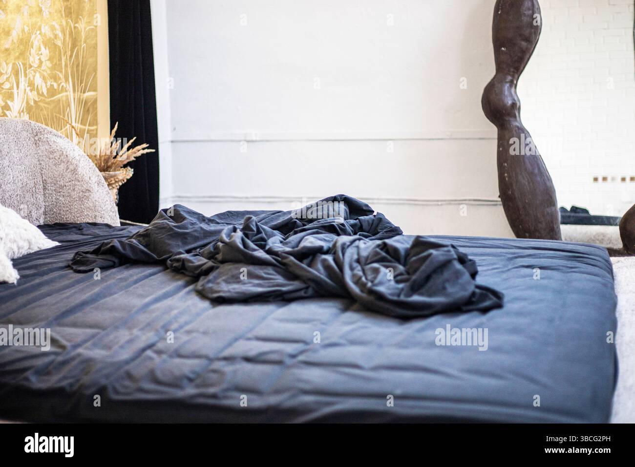 stylish modern crumpled sheet on double bed in modern interior Stock ...