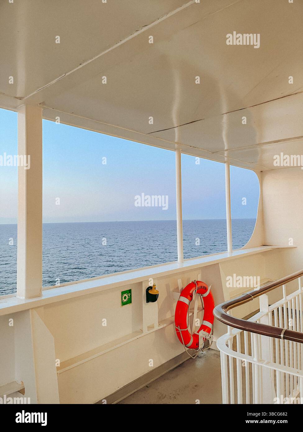View of calm ocean horizon at sunset from the deck of a ship, with ...