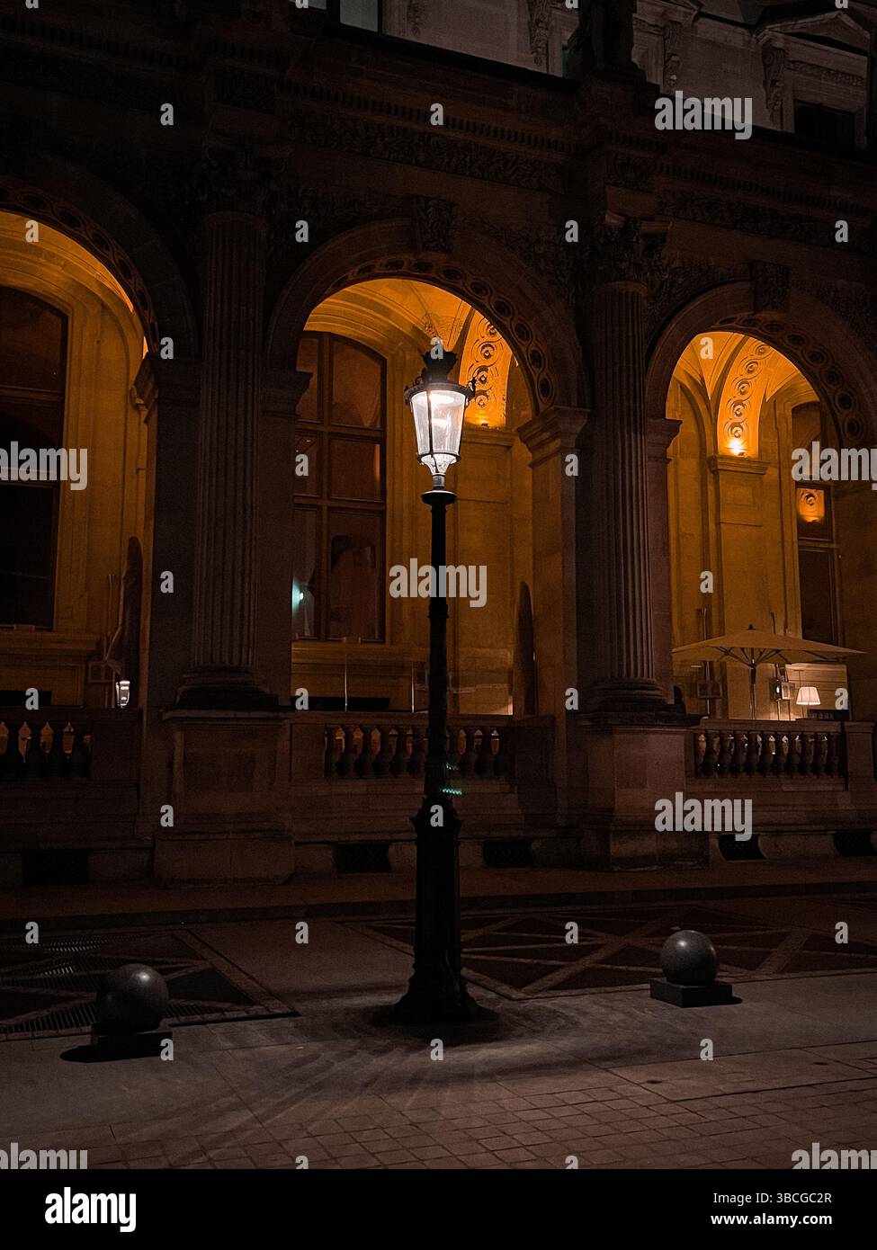 Vintage street lamp glowing warmly in front of an elegant historic ...