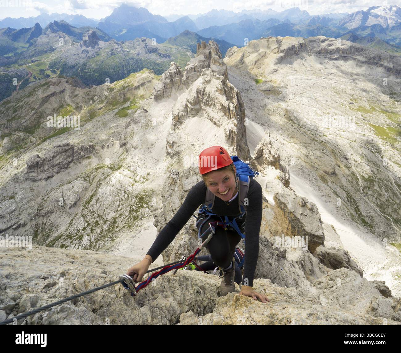 Horizontal view of an attractive female climber on a steep Via Ferrata ...
