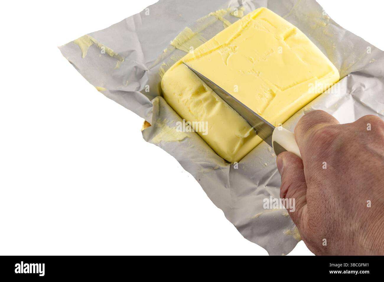 A cube of yellow butter on a white background, cutting butter for ...