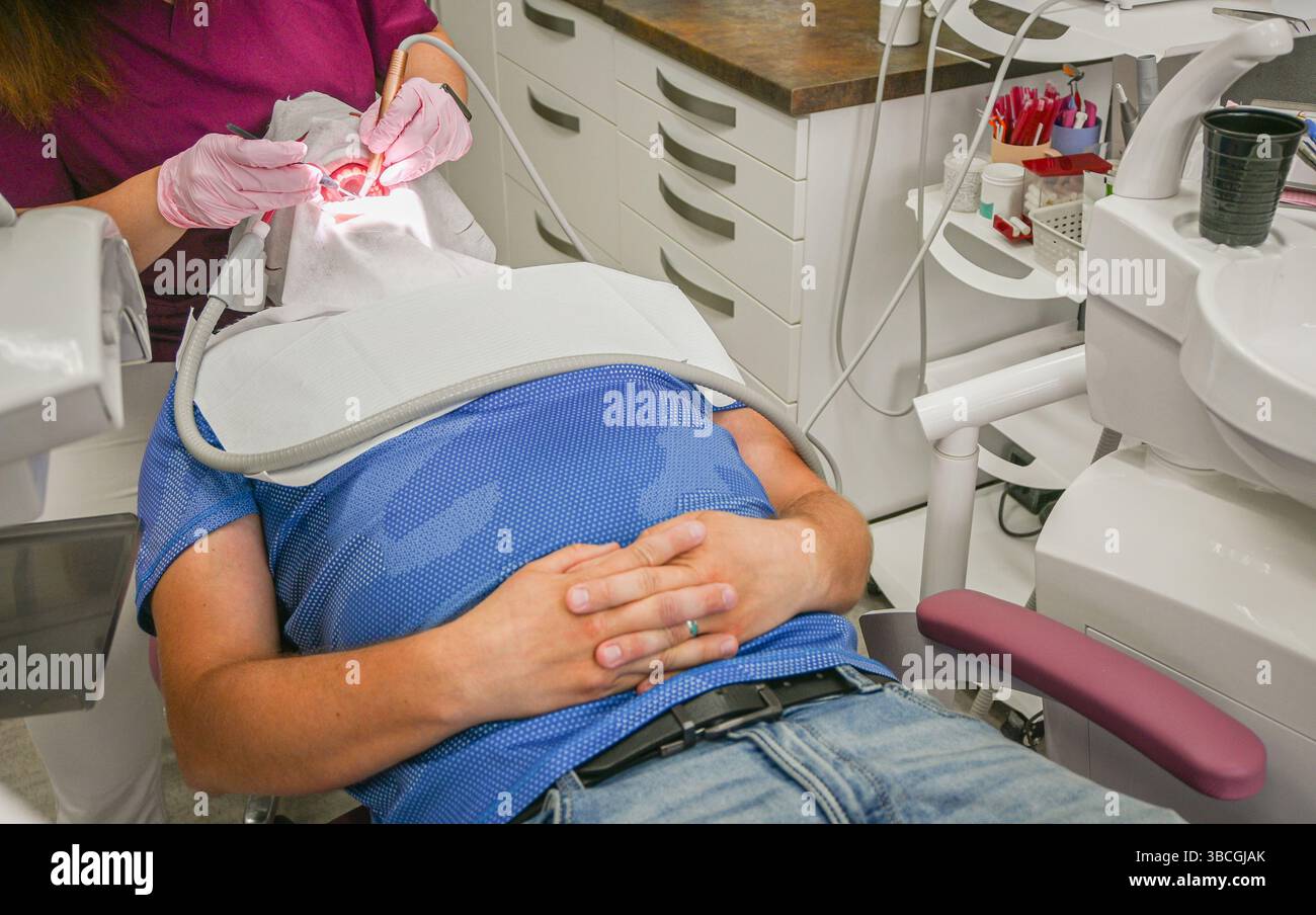 Dentist performing dental examination using a dental drill on a patient ...