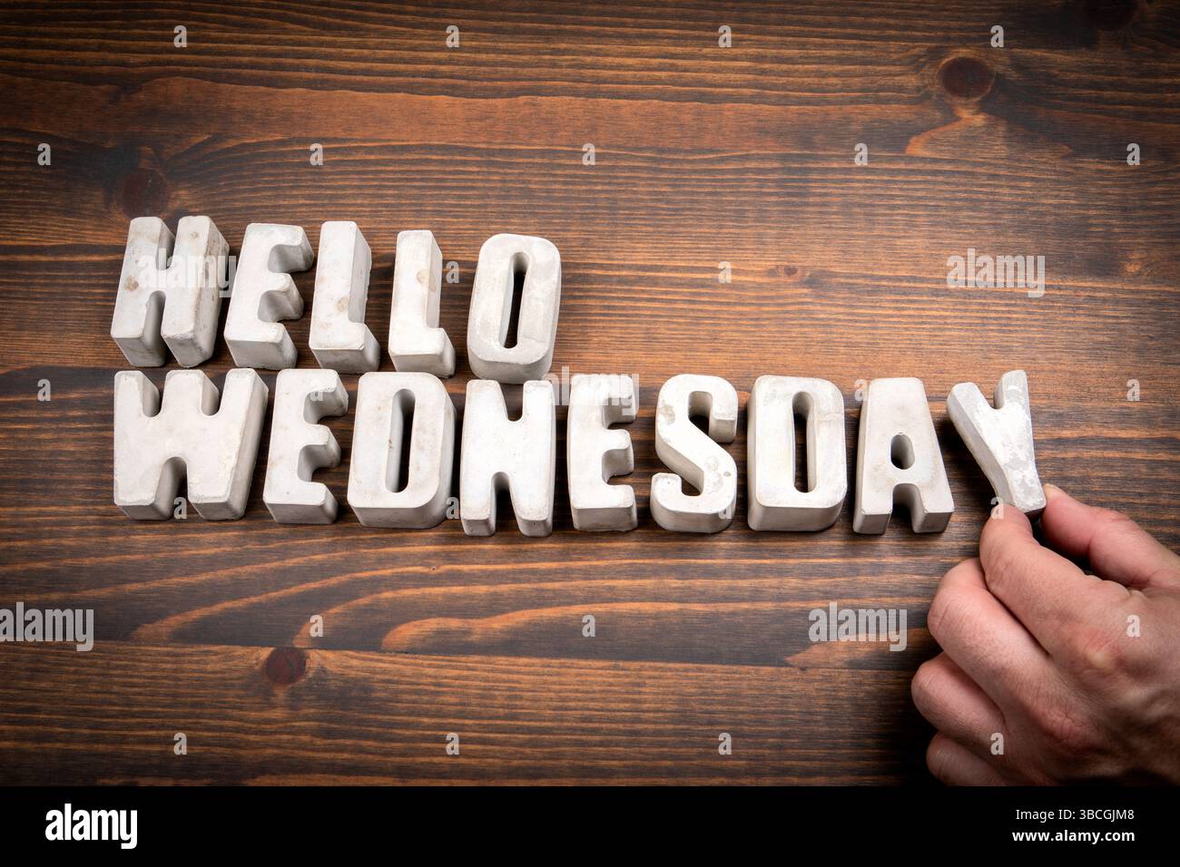 Hello Wednesday. Concrete alphabet letters and coffee mug on dark ...
