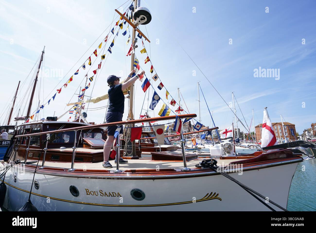Crew member Rachel Turner securing flags on the Bou Saada as Little ...