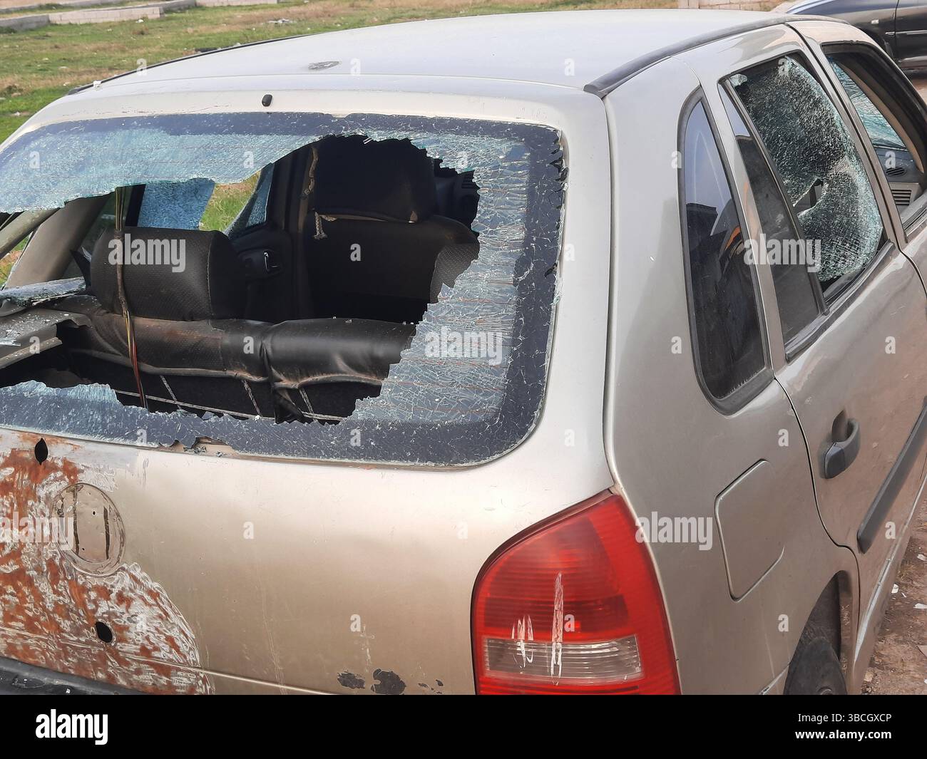 Breaking into a car parked on the street. Broken side and back glasses ...