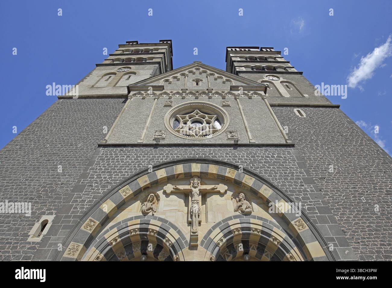 Portal with twin towers of the Herz-Jesu-Kirche built in 1912, crucifix ...