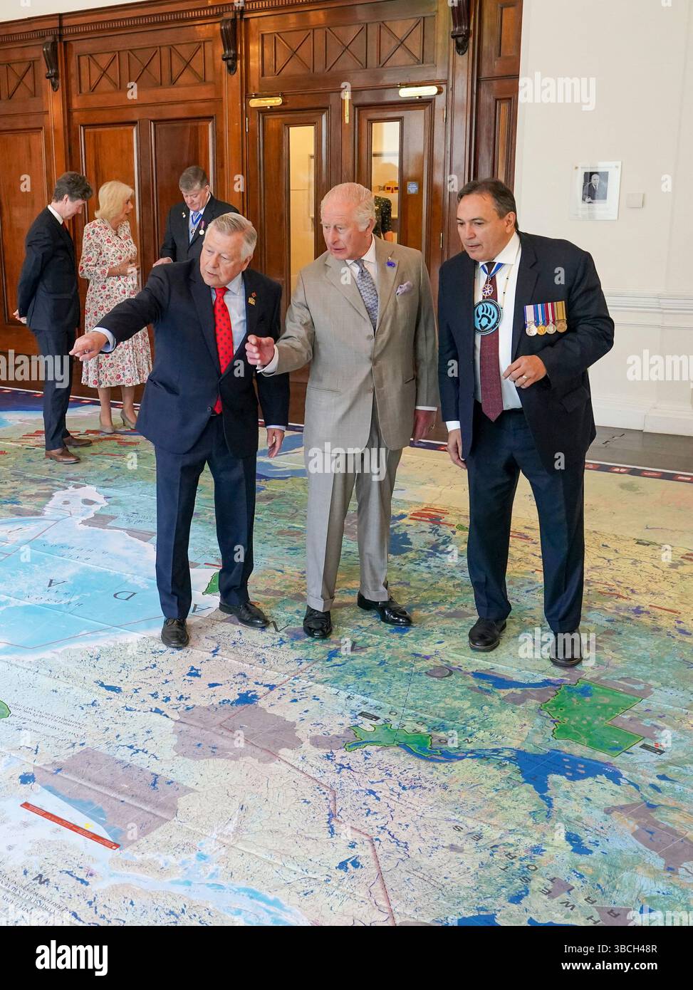 King Charles III views a map of Canada with High Commissioner for ...
