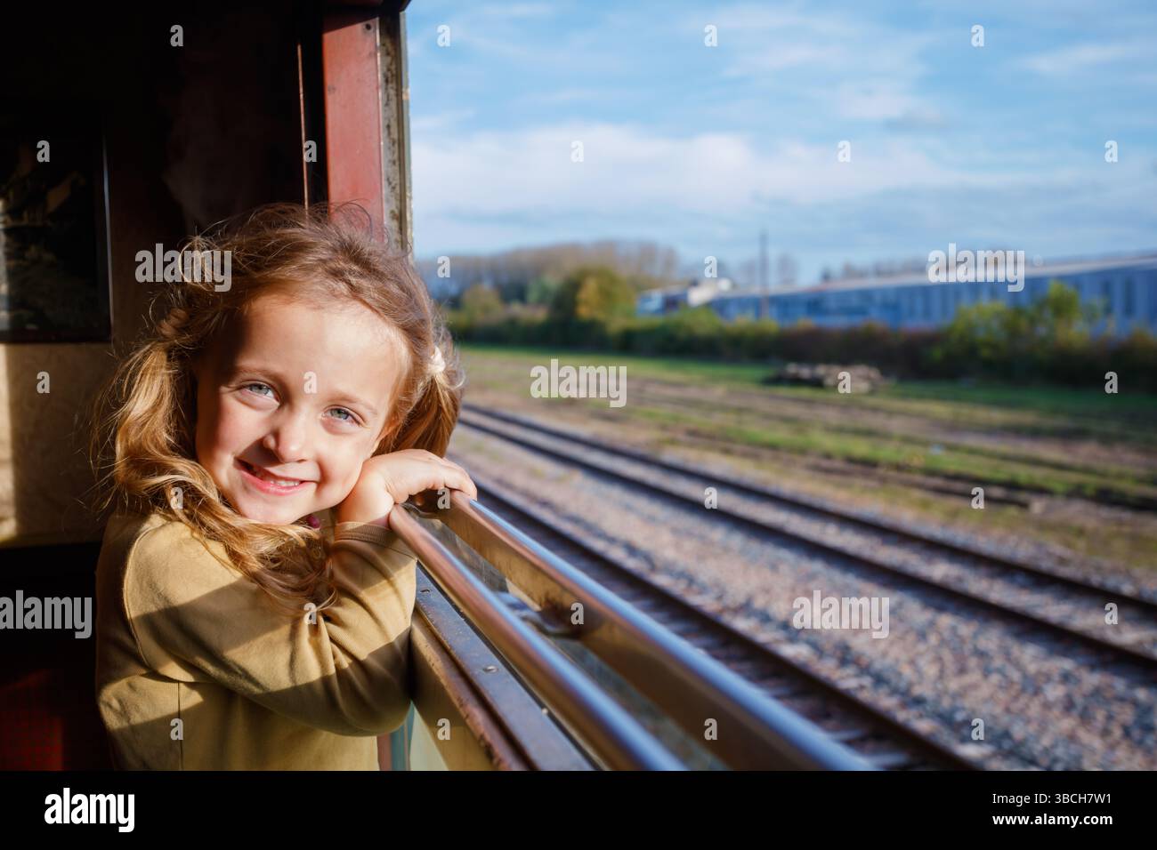 Smiling girl leans from carriage window at passing landscape Stock ...
