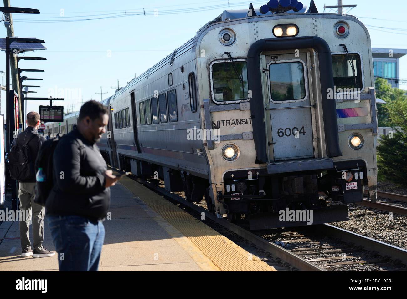 People wait to board a NJ Transit train in Hackensack, N.J., Tuesday ...