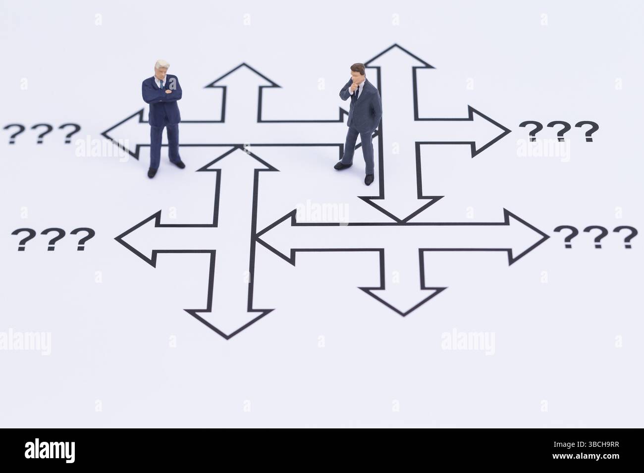 The photo shows two figures with different arrows and question marks ...