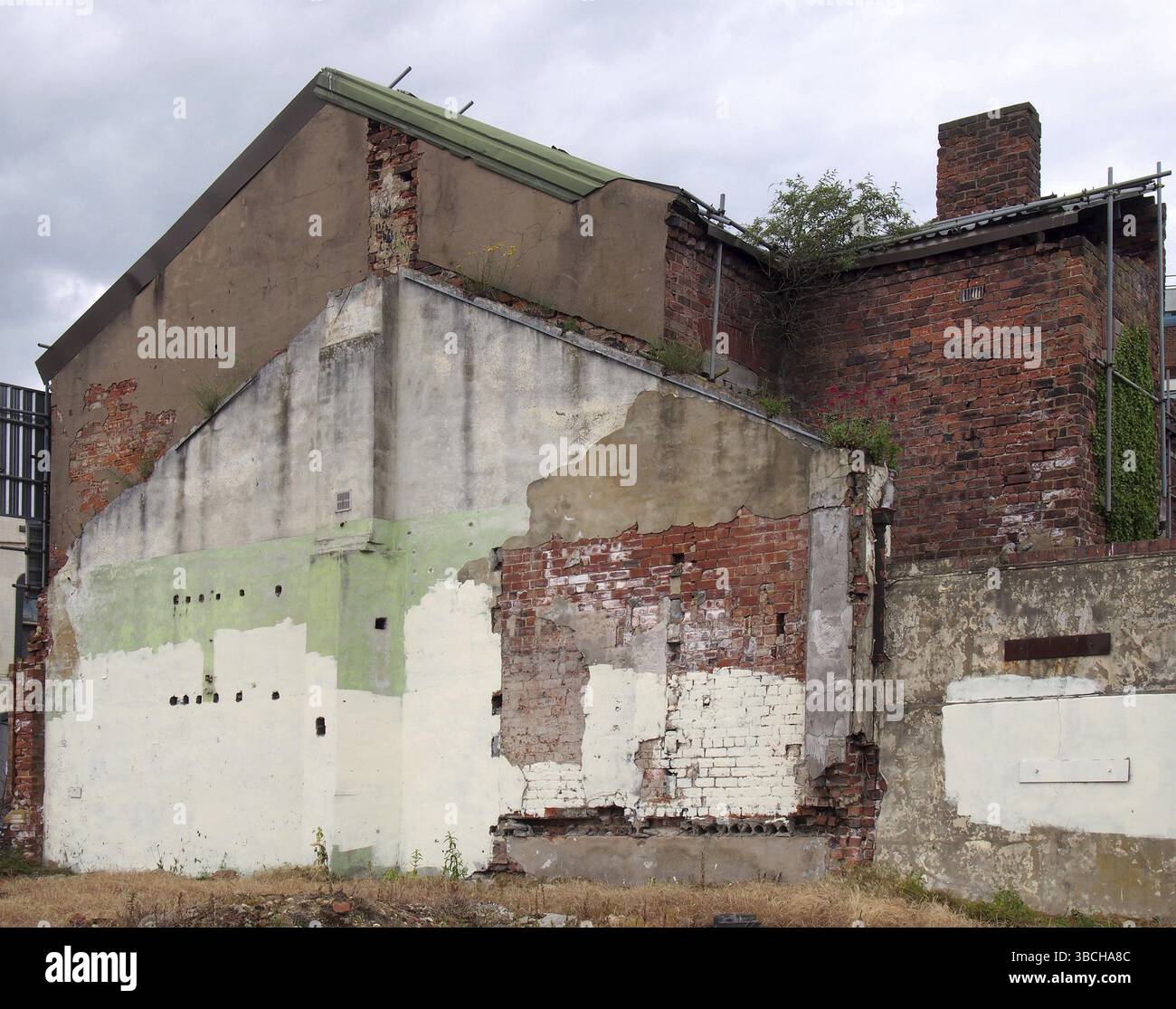 An abandoned derelict old house with crumbling brick walls propped up ...