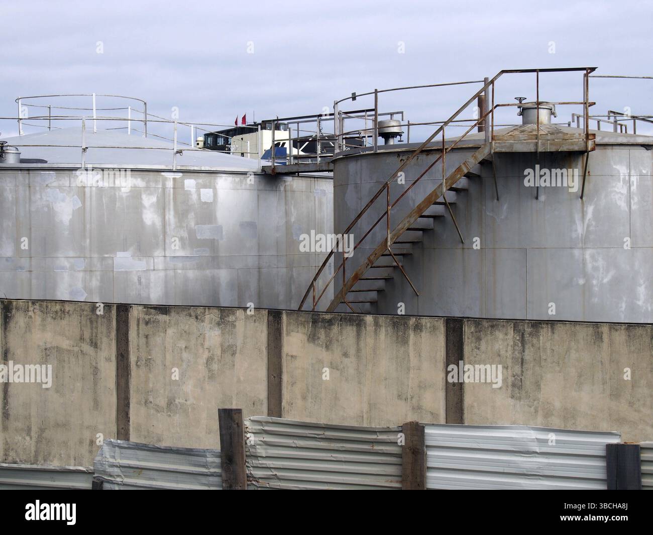 Old steel industrial storage tanks with rusty stairs and walkways ...