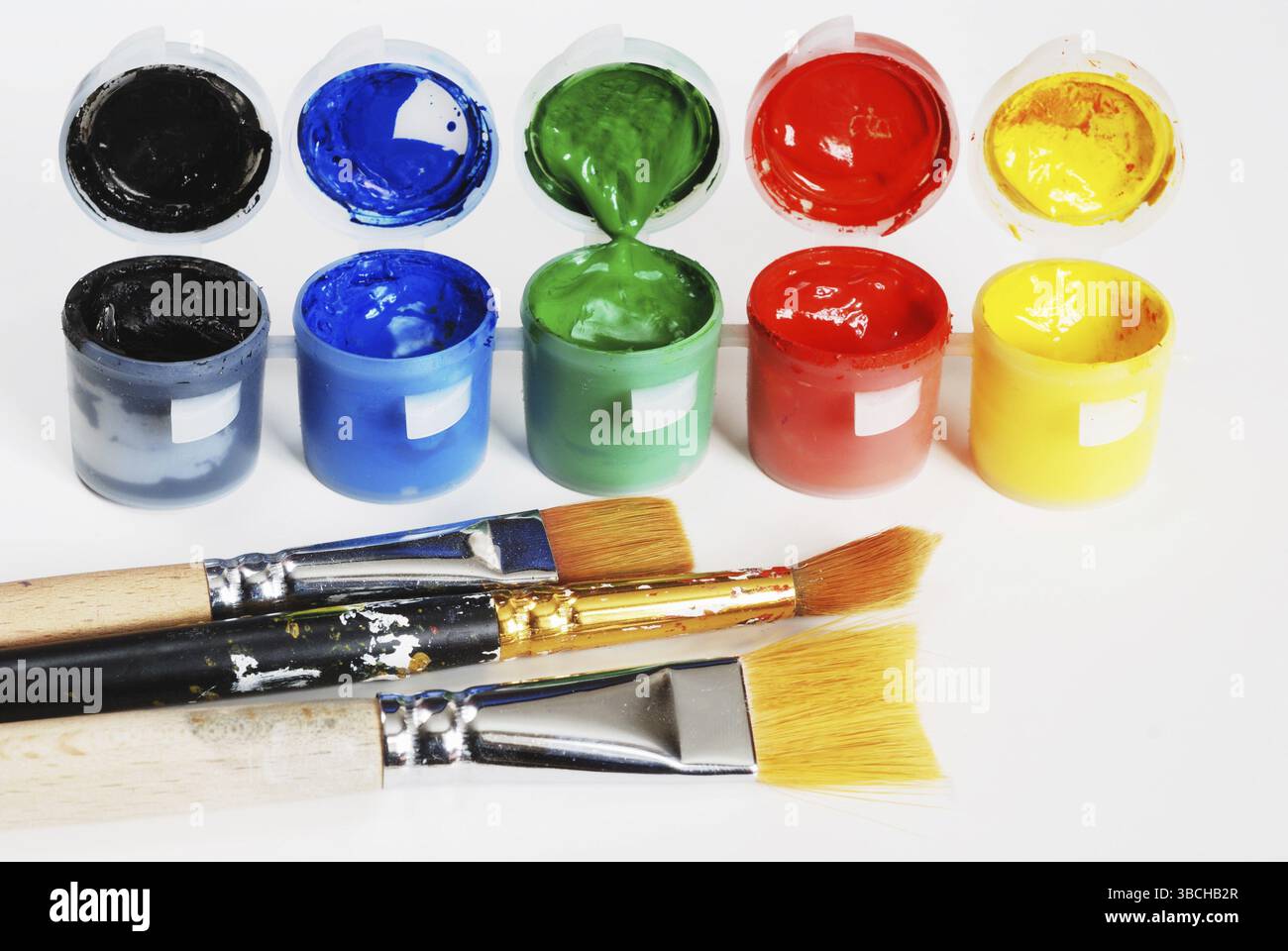 Plastic containers with paint, black, blue, green, red, yellow and ...
