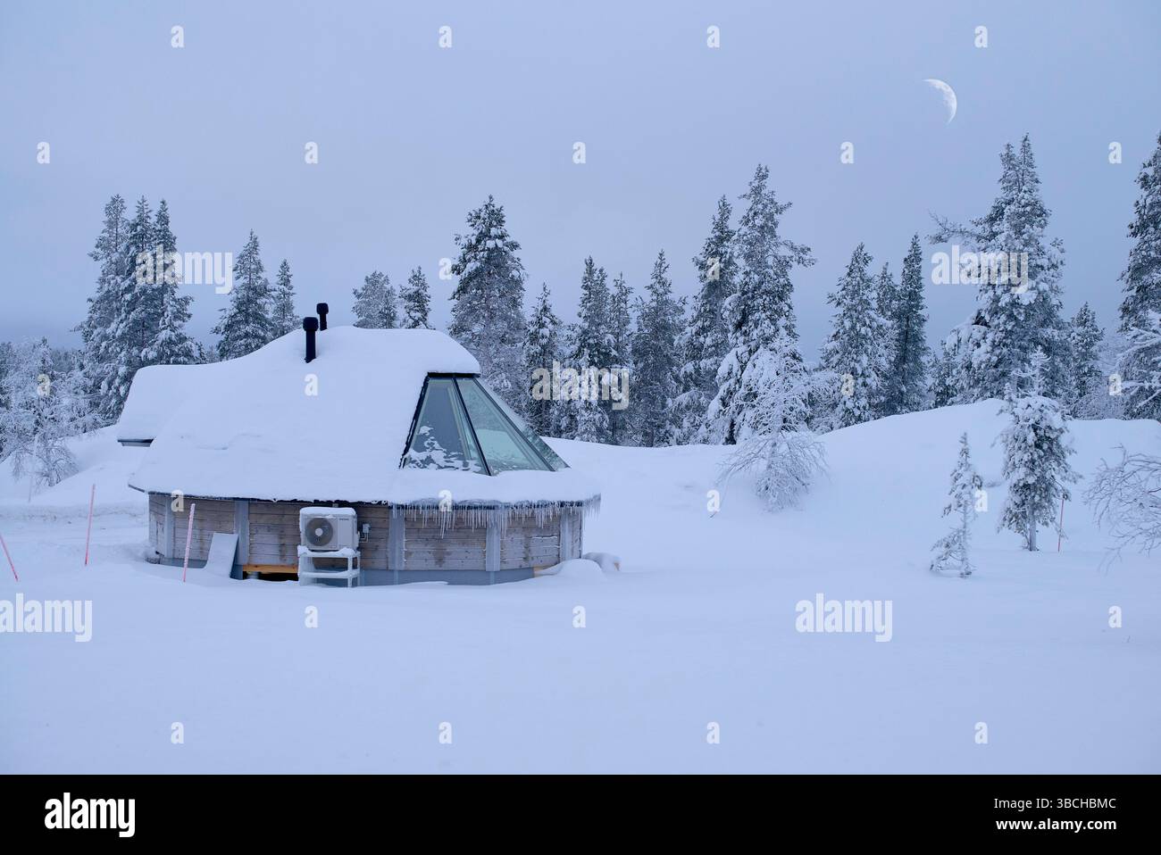 Snow-covered wooden cabin with triangular window amidst snowy pine ...