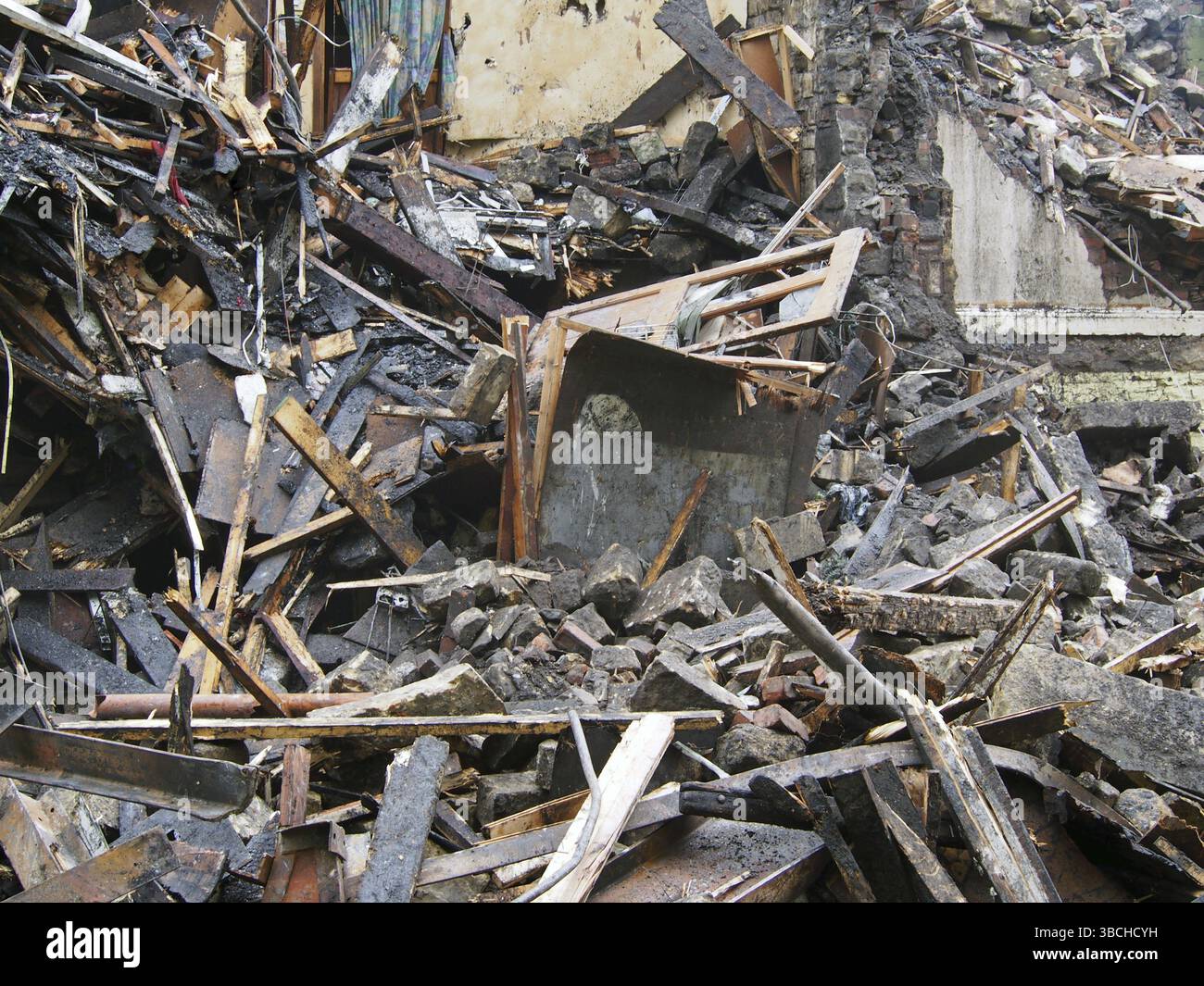 Black burned timbers and walls in a collapsed house destroyed by fire ...