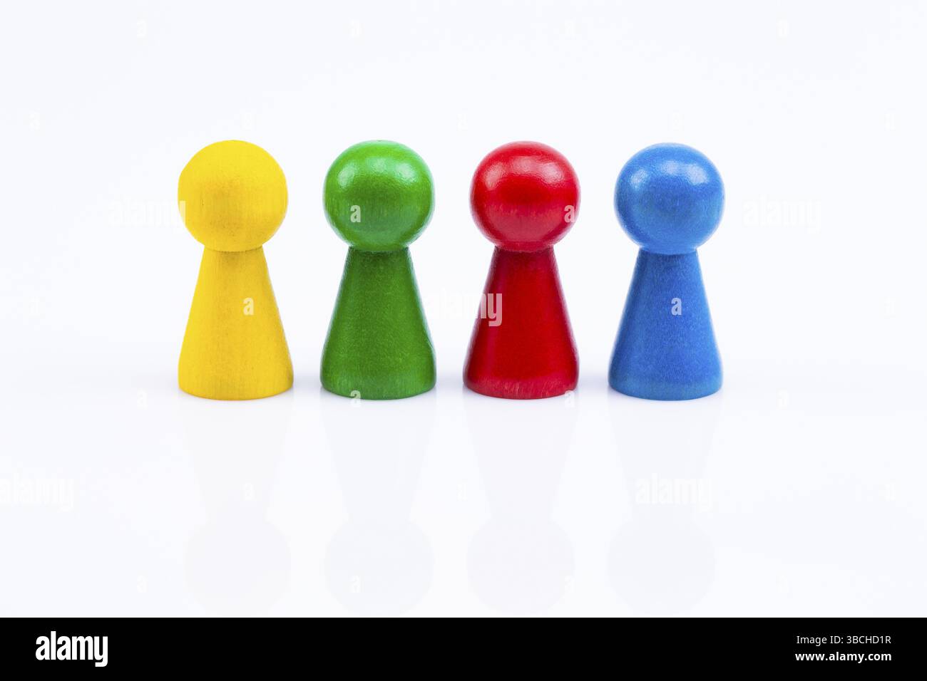 The photo shows different coloured wooden figures in front of a white ...