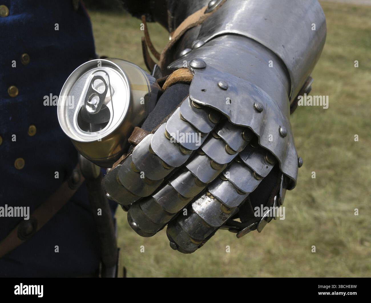 Hand of a medieval knight wearing metal armour squeezing a tin Stock ...