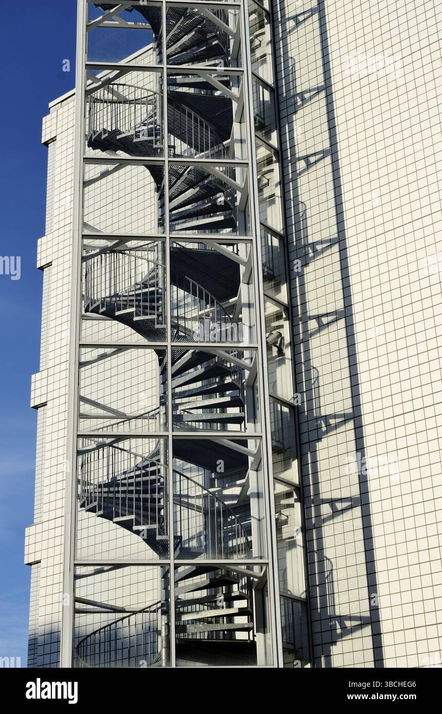 Modern fire escape twisted sunlit, vertical photo Stock Photo - Alamy