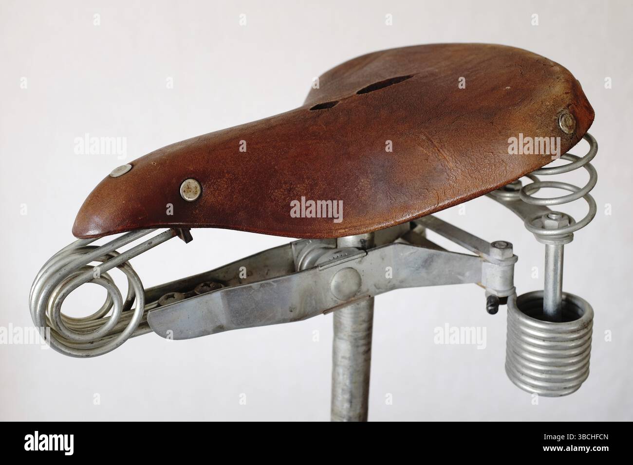 Old-fashioned vintage leather bike saddle with metal spring Stock Photo ...