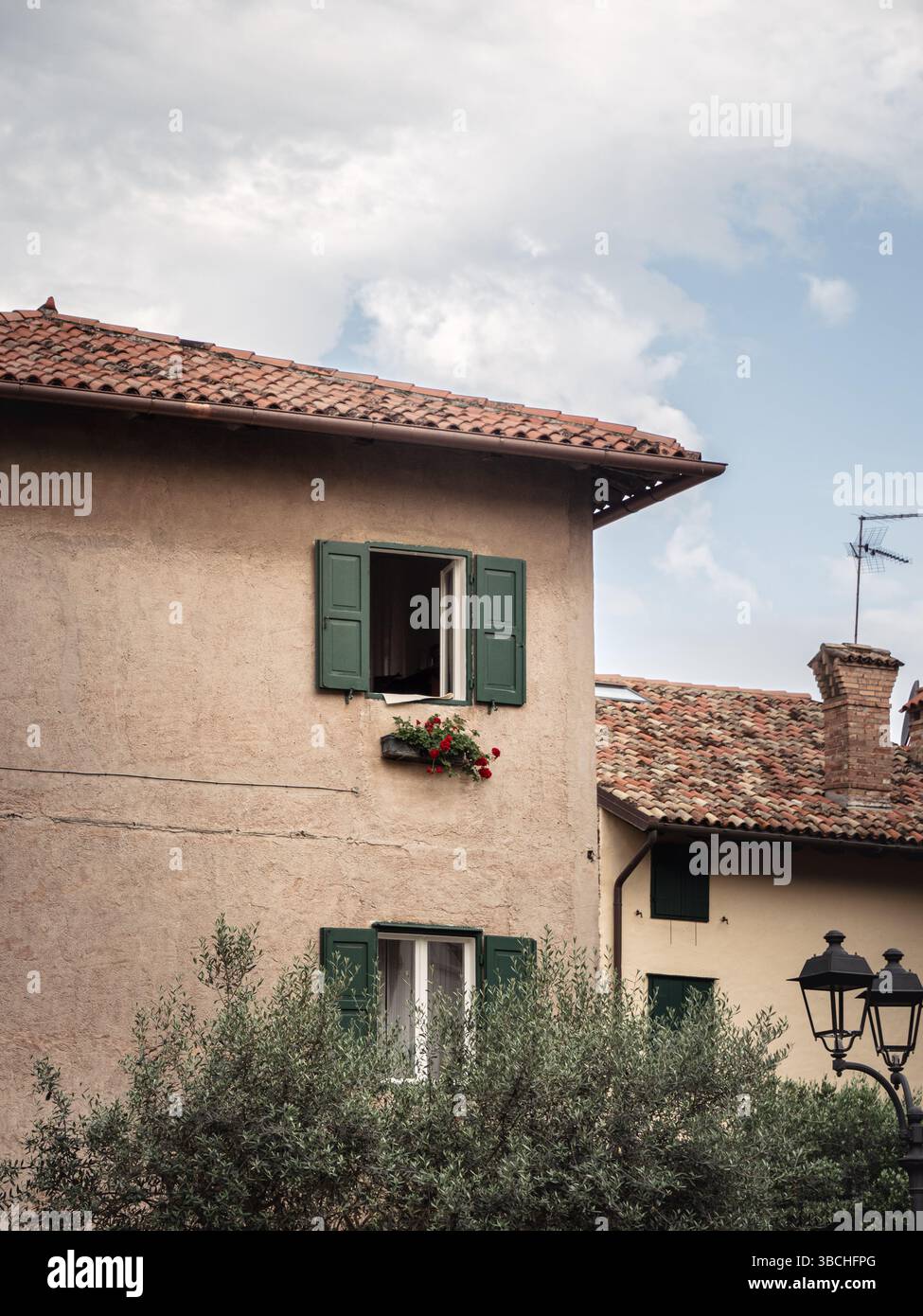 Rustic house in Grado, Italy with green shutters, a flower box ...