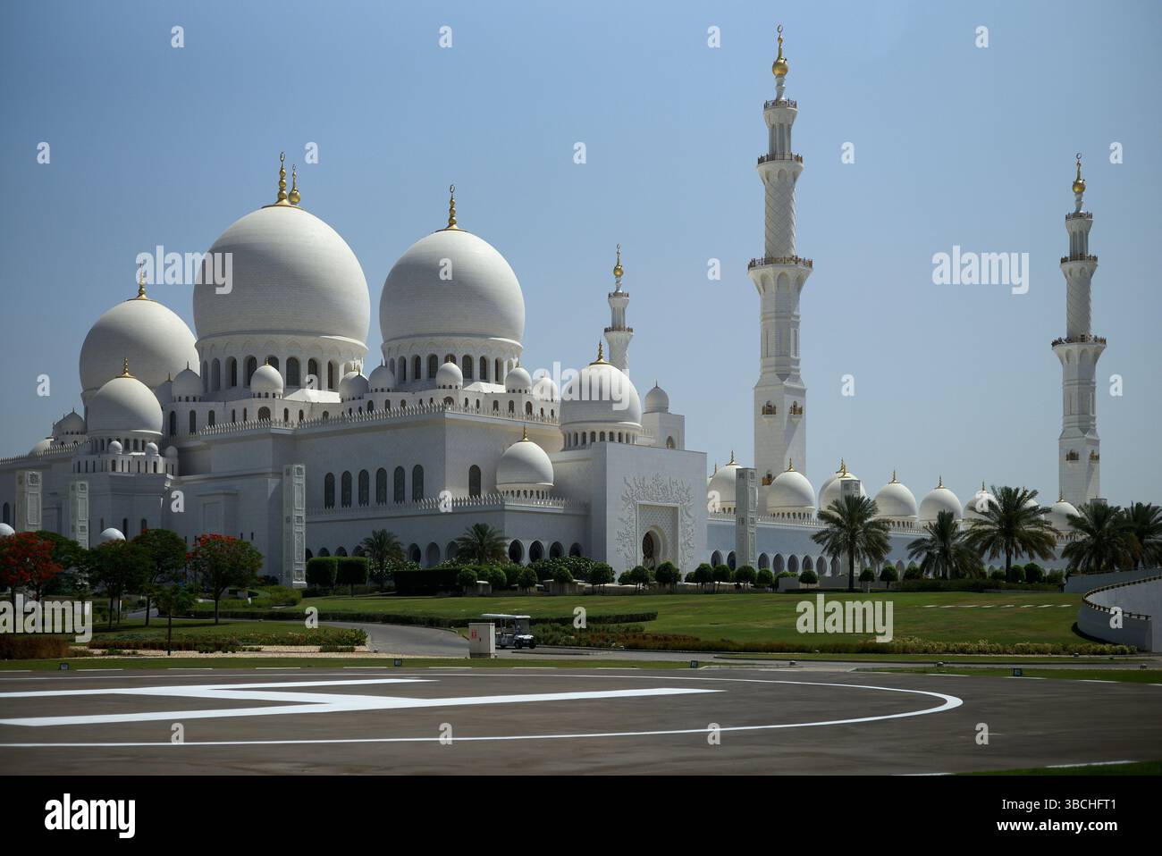 Majestic white mosque with grand domes and tall minarets under a clear ...