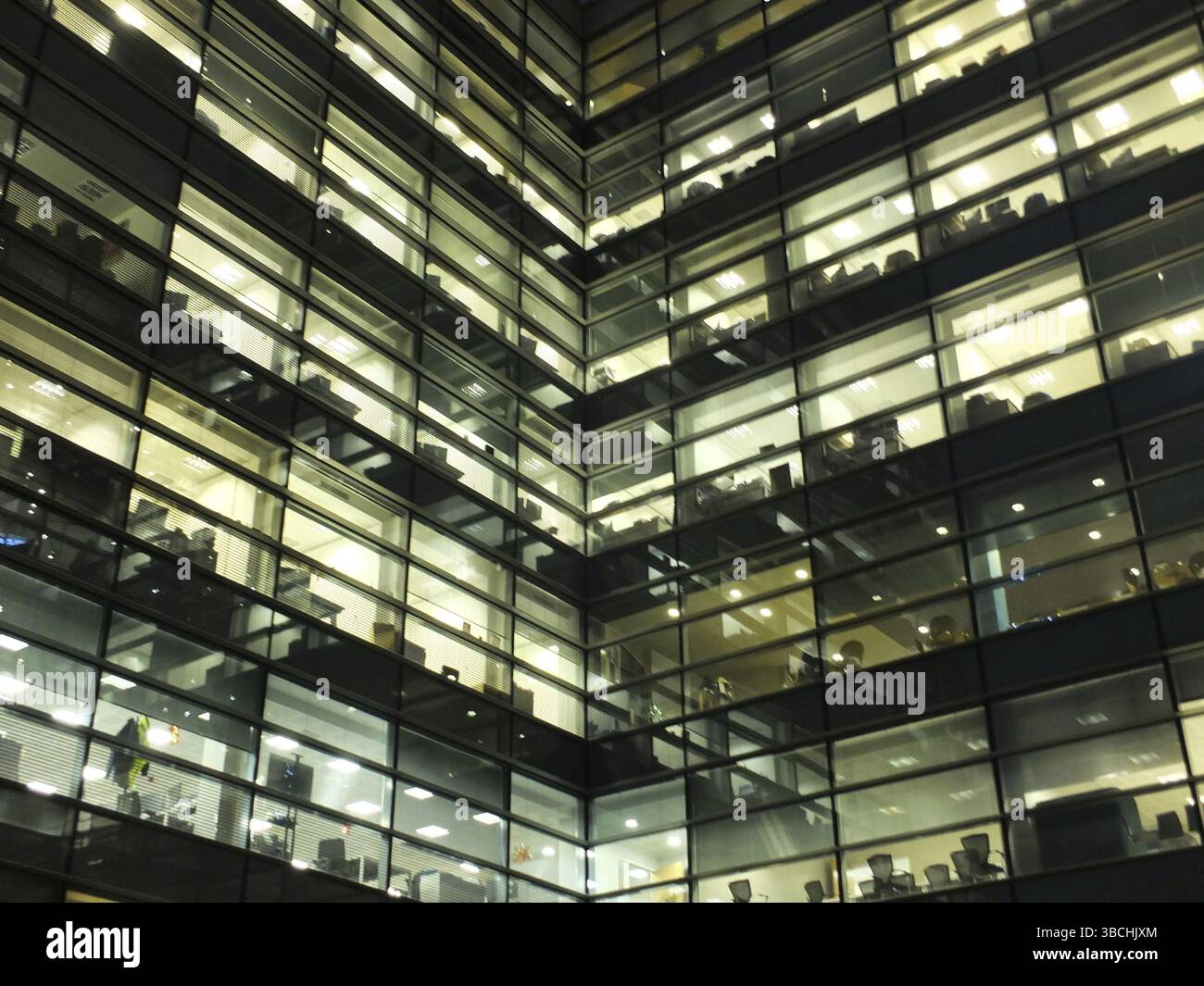 Glowing illuminated windows in a large modern geometric city office ...