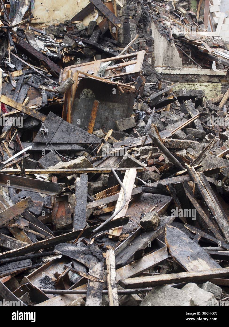 Black burned timbers planks and debris in a collapsed house destroyed ...