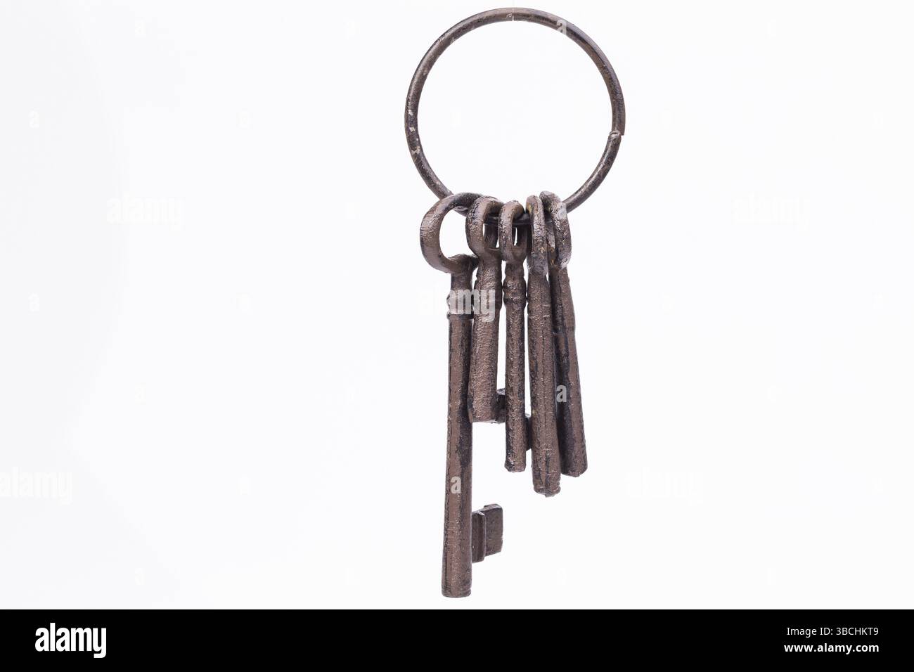 The photo shows an old, rusty bunch of keys against a white background ...