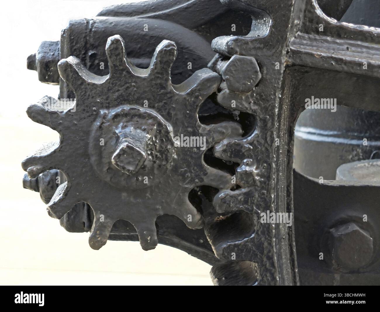 A close up of old worn black painted large cog wheels with gear teeth ...