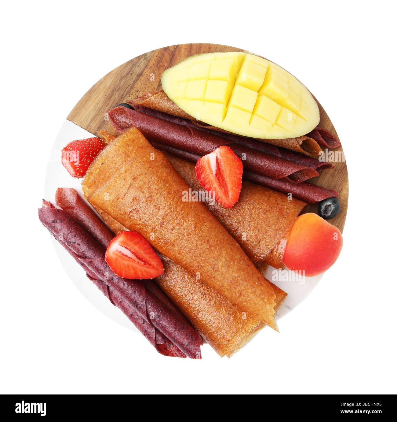 Delicious fruit leather rolls, berries and mango isolated on white, top ...
