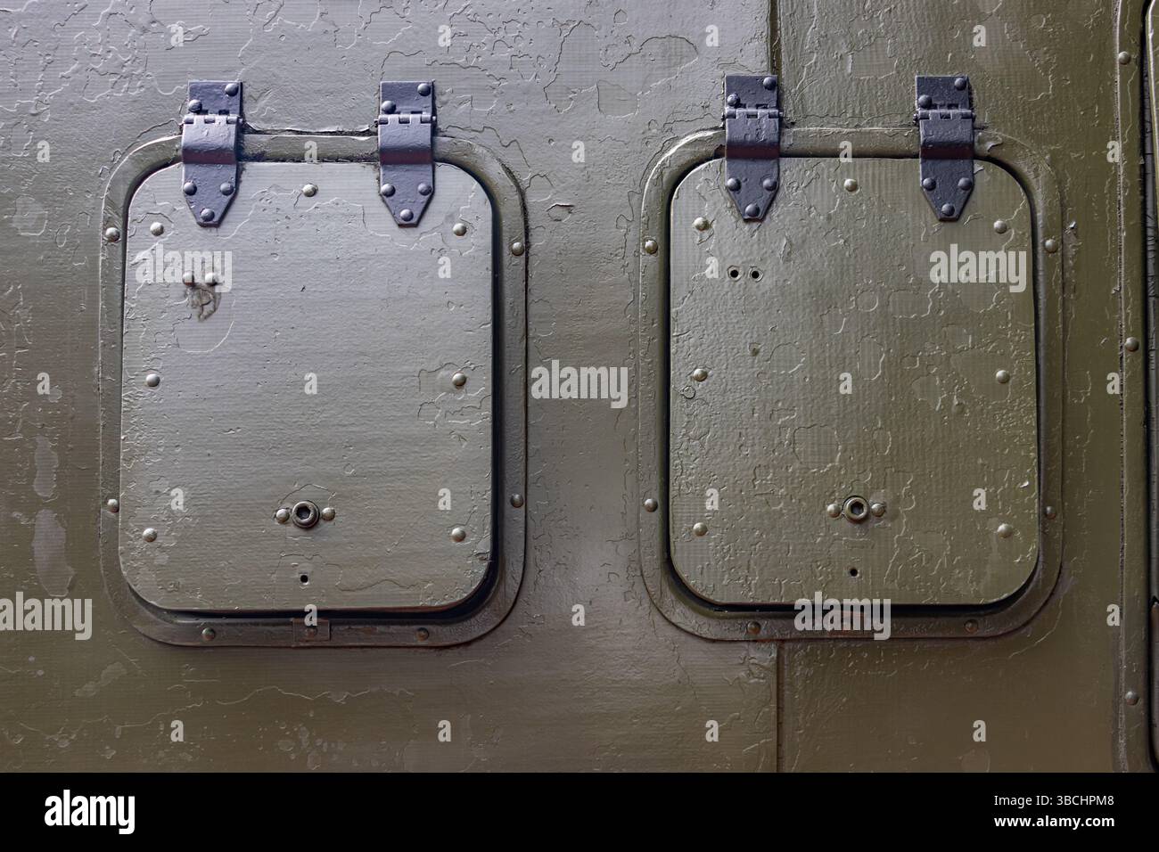 Green metal hatches with hinges on the armored body of a military truck ...