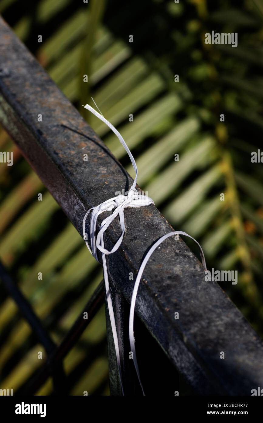 white plastic string twine knotted round a square black iron post Stock ...